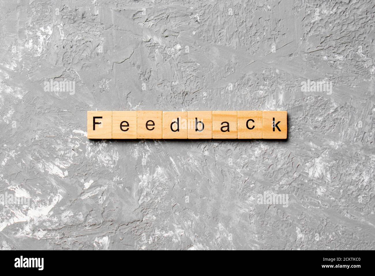 feedback word written on wood block. feedback text on cement table for ...