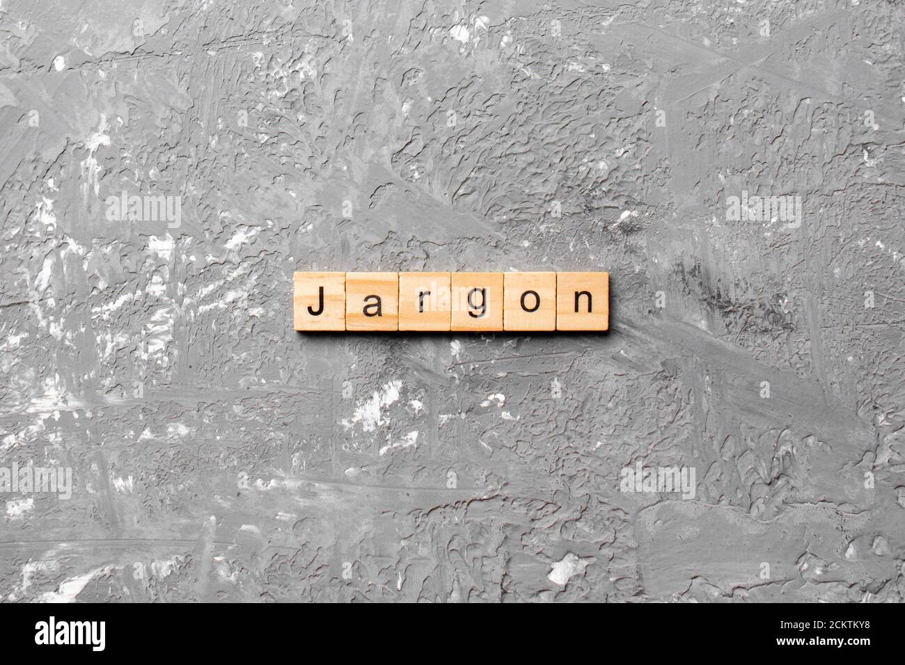 Jargon word written on wood block. Jargon text on cement table for your ...
