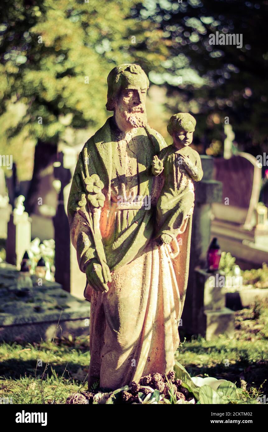 stone statues among graves in the cemetery Stock Photo - Alamy