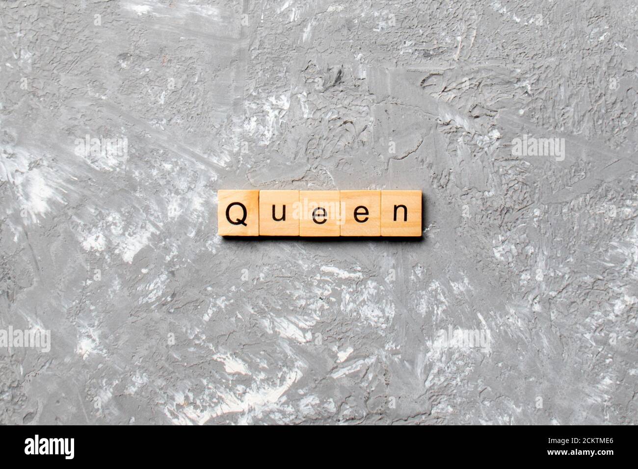 queen word written on wood block. queen text on cement table for your ...