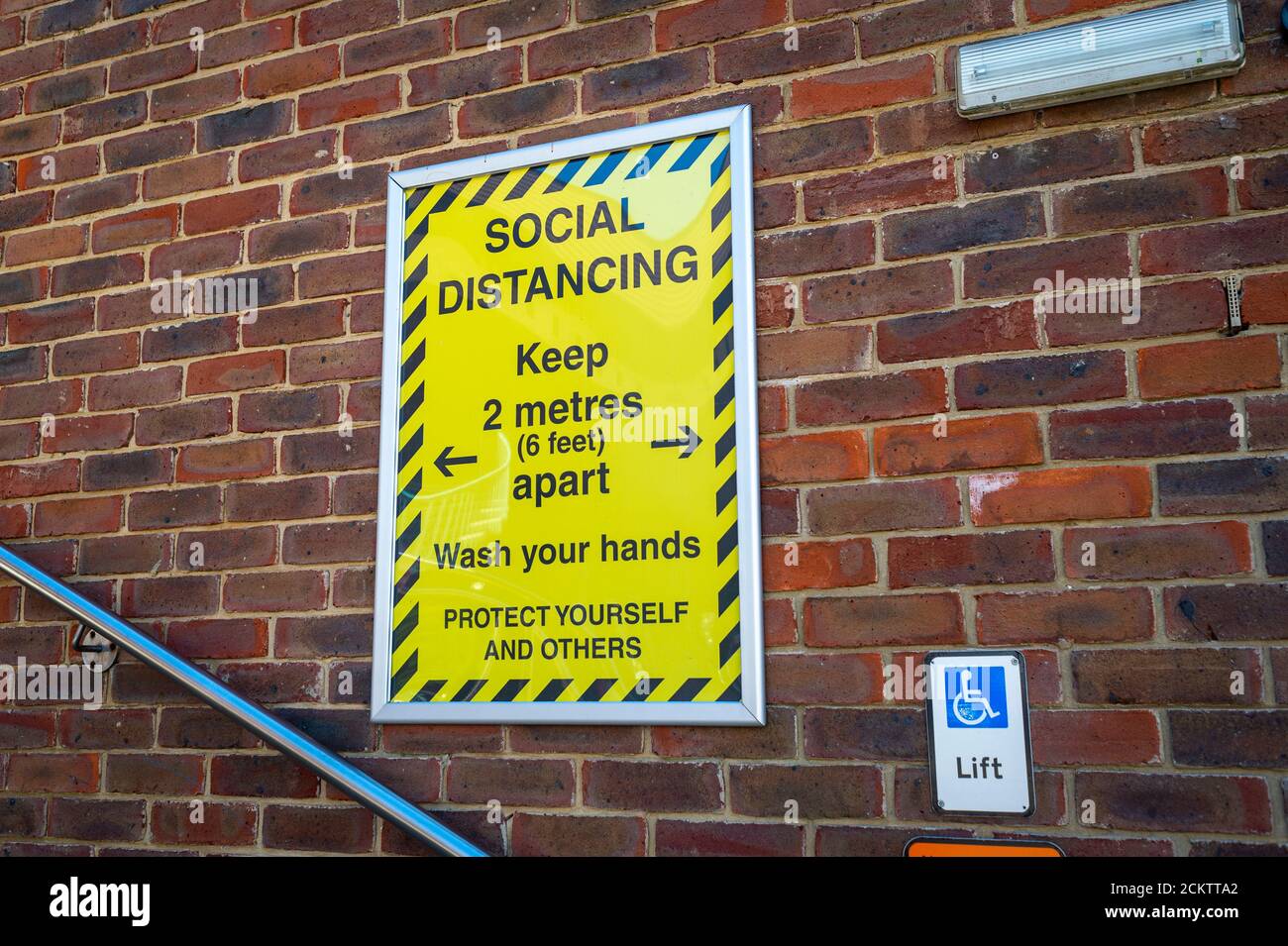 social distancing sign on a wall. Keep 2m apart and wash hands. Covid ...
