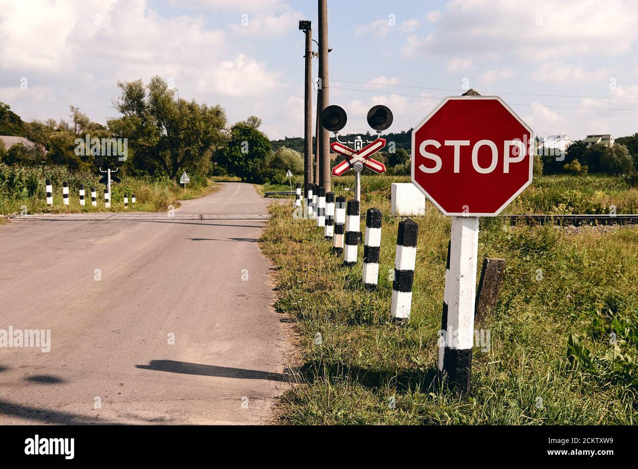 Railroad crossing with a Stop sign. Train rails in country landscape ...