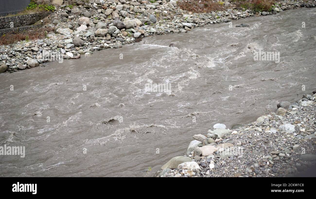 Mountain river in Caucasus. Mountain dirty river flows fast Stock Photo ...