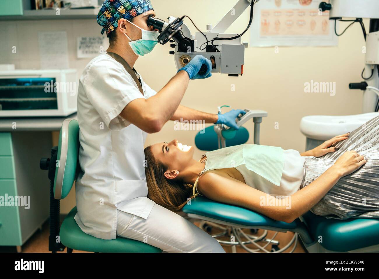Dentist examine oral cavity of female patient with microscope Stock ...