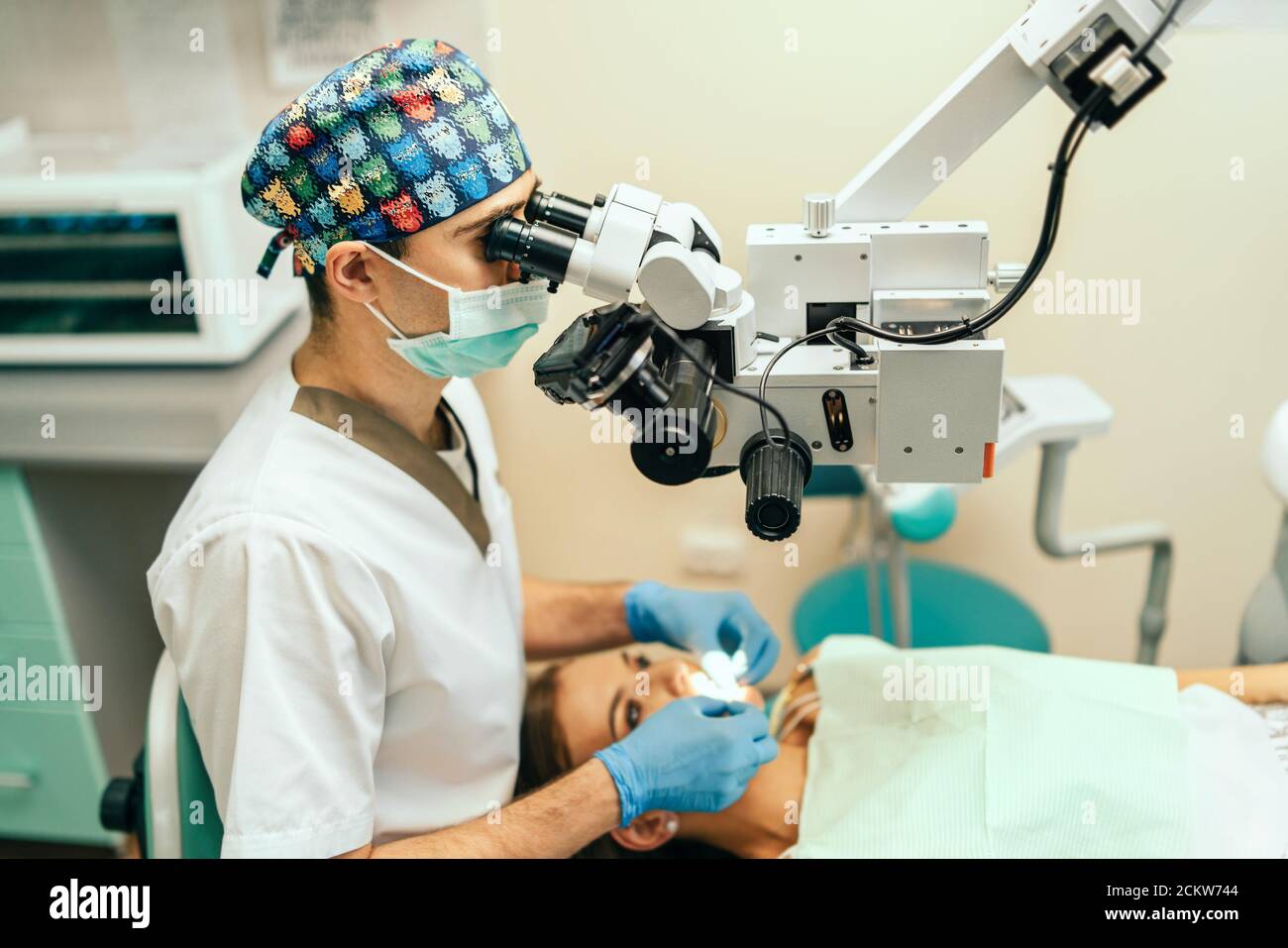 Dentist examine oral cavity of female patient with microscope Stock ...