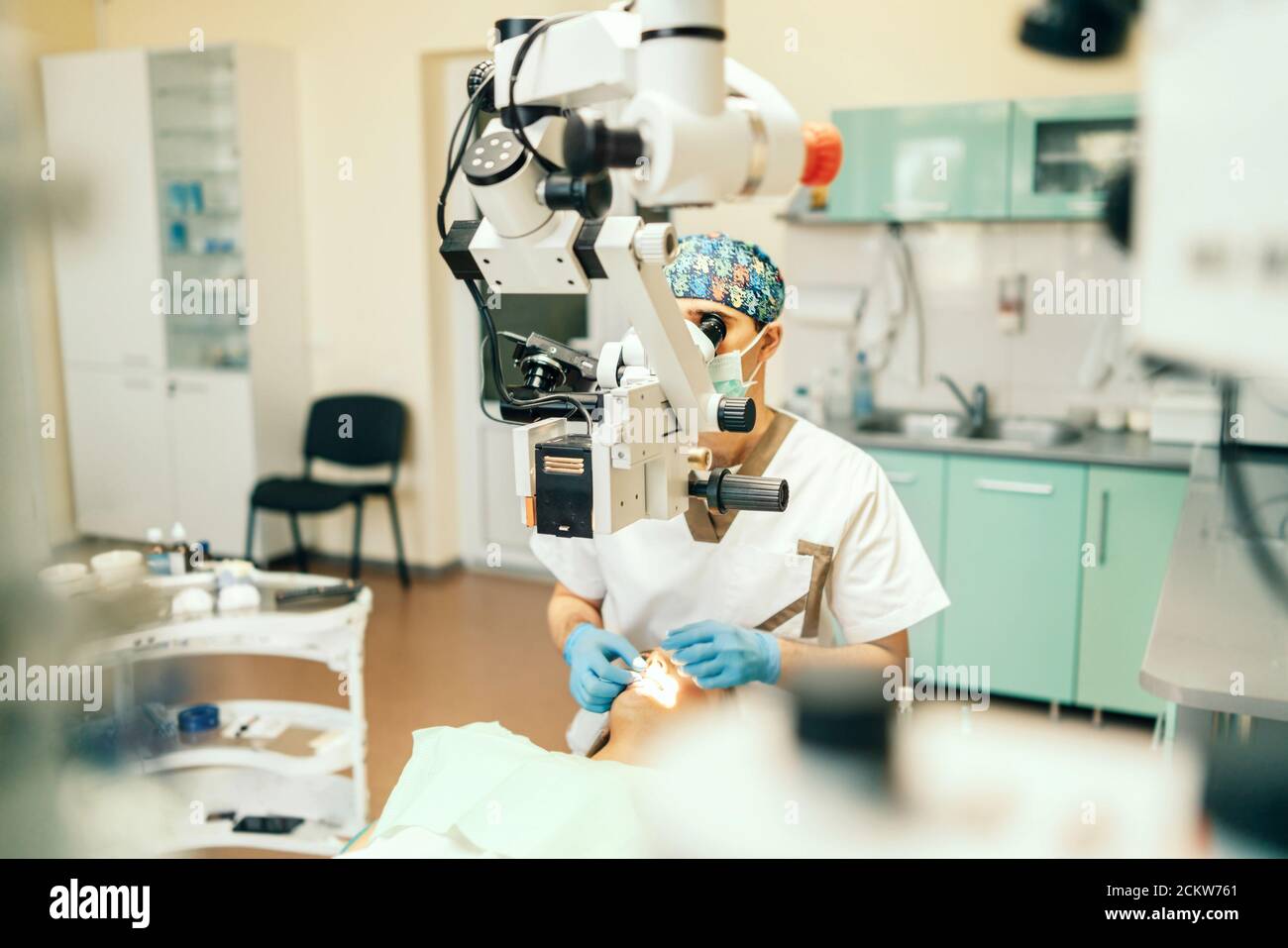 Dentist examine oral cavity of female patient with microscope Stock ...