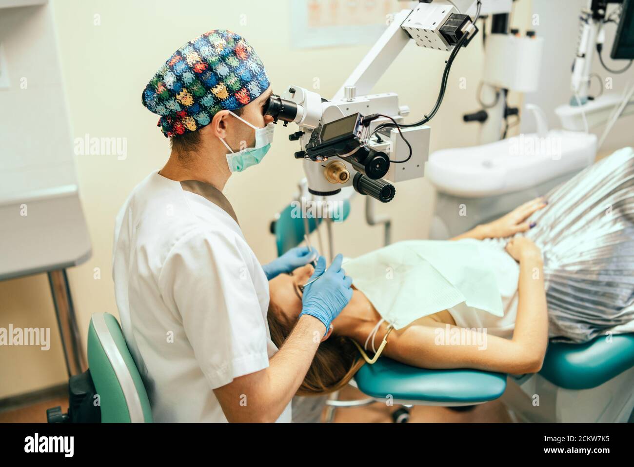 Dentist examine oral cavity of female patient with microscope Stock ...