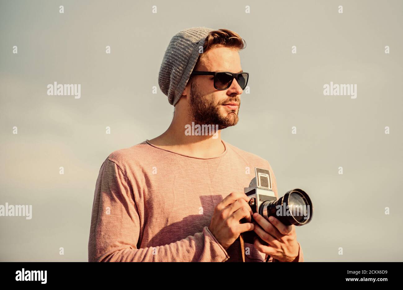 Hipster reporter taking photo. Guy photographer outdoors sky background ...