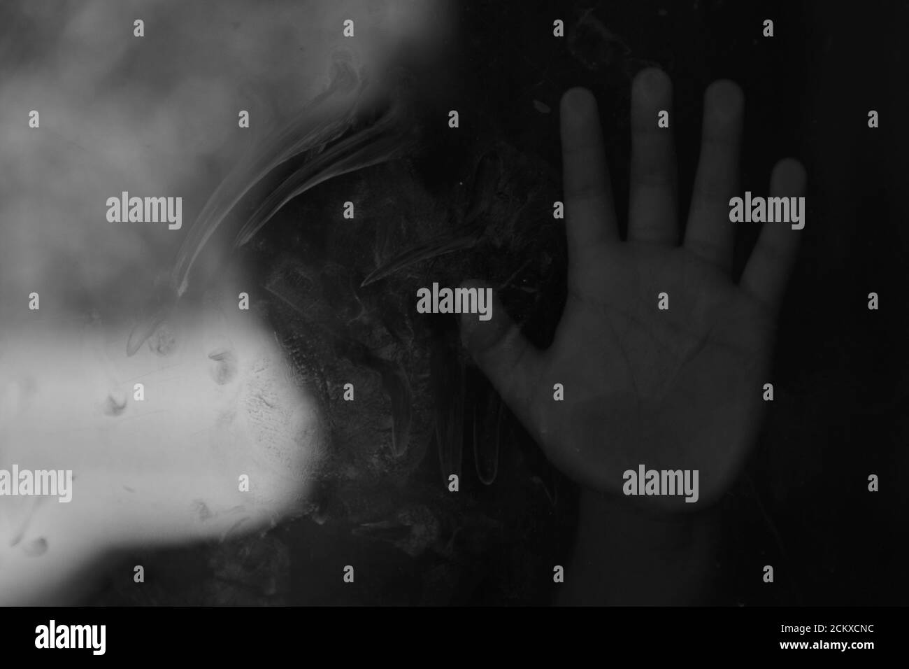 Monochrome of a child's hand against a glass window - - abuse ...