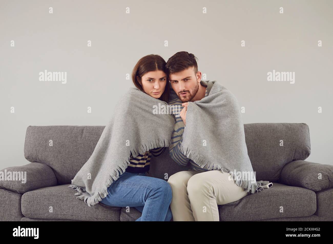 Freezing couple in cool room cuddling in plaid Stock Photo - Alamy