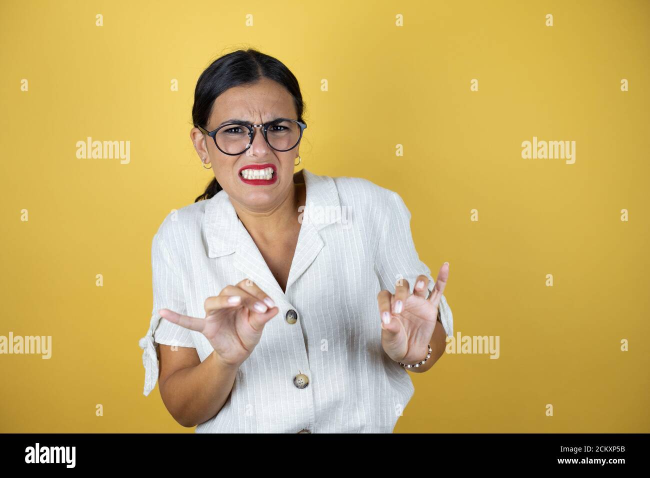 Beautiful woman over yellow background disgusted expression, displeased ...