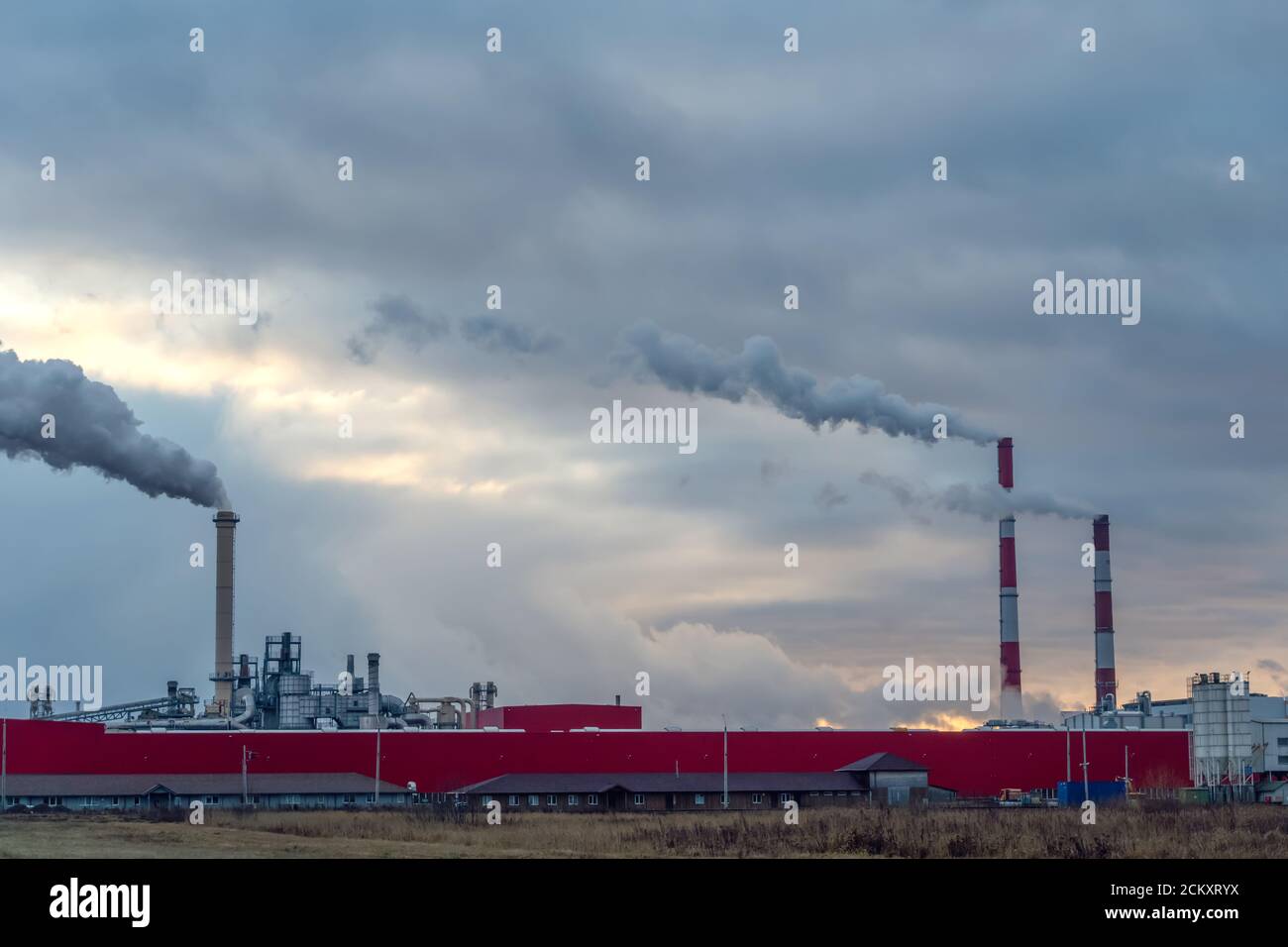 Smoky factory chimneys against a blue-gray sky. Environmental pollution ...