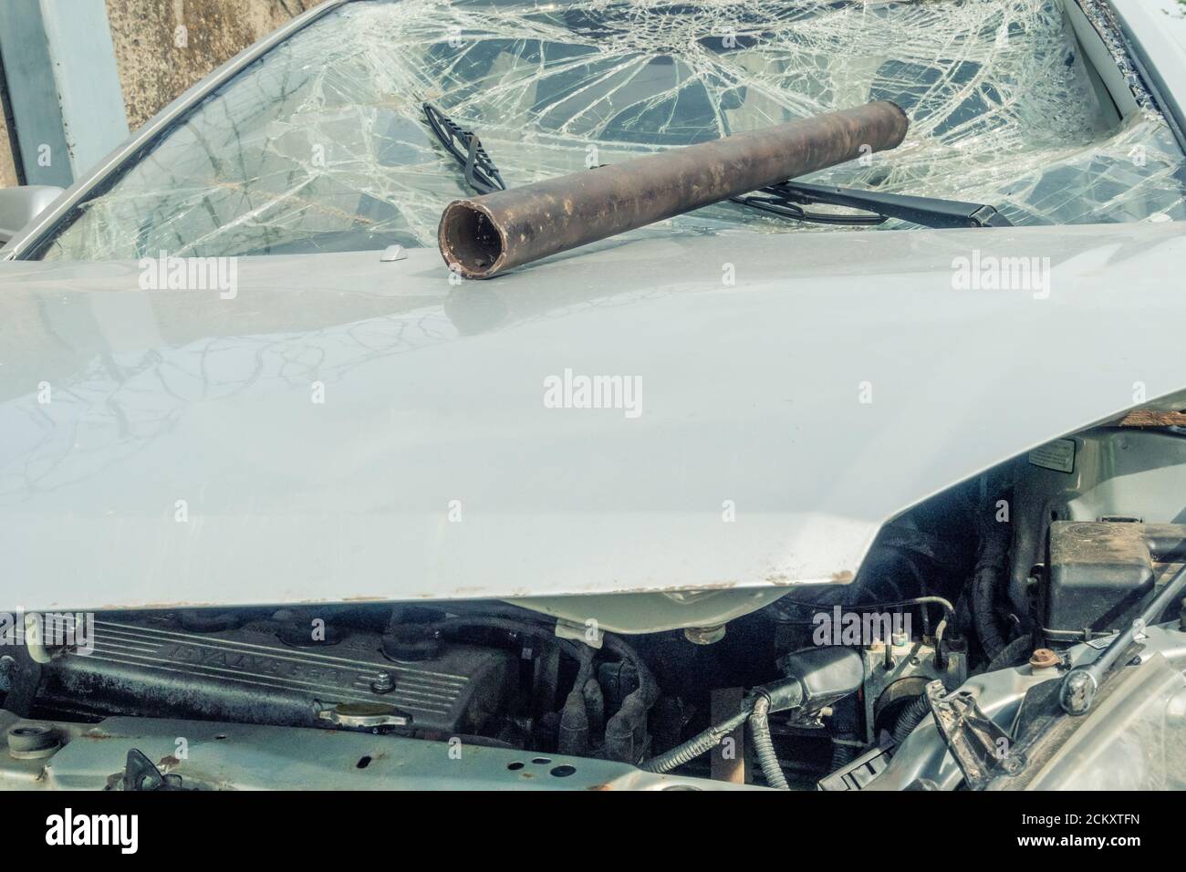 Iron pipe on a broken windshield and hood. Car after the accident ...