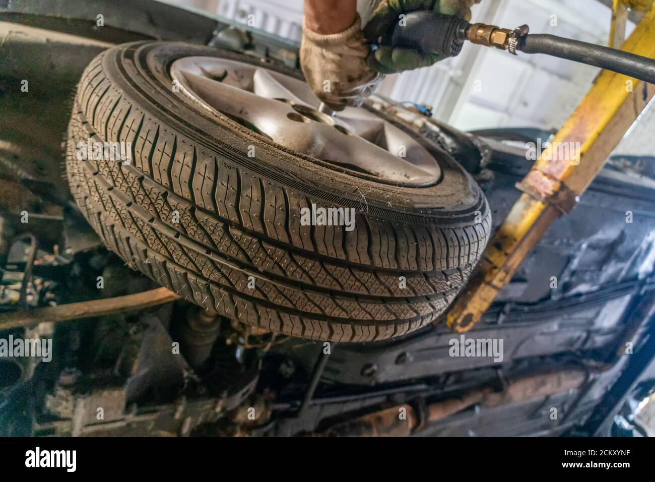 Mechanic with a wrench changes the wheels. Car service. Hands replace ...