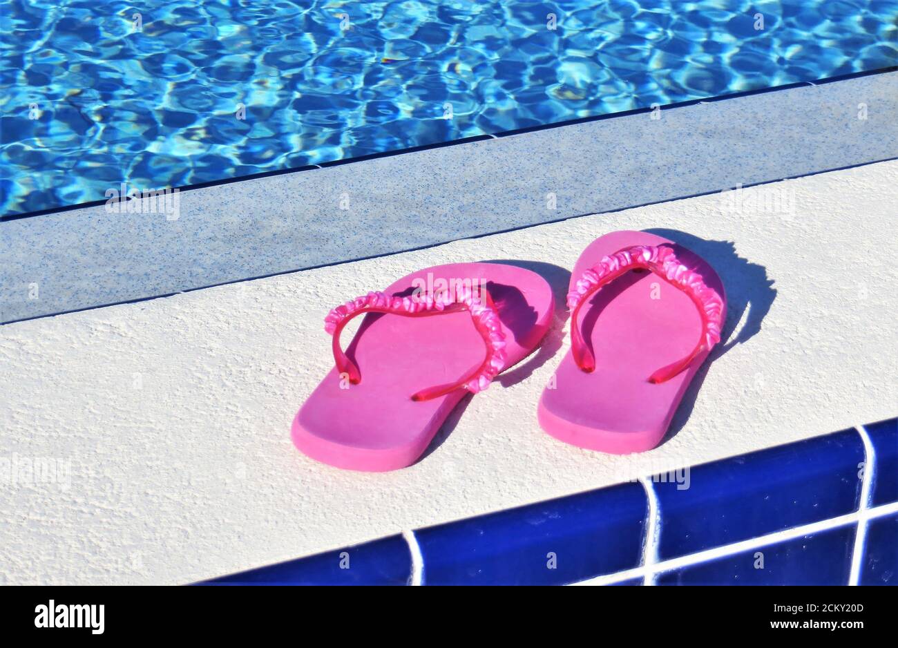 Colorful flip flops by the edge of a swimming pool Stock Photo - Alamy