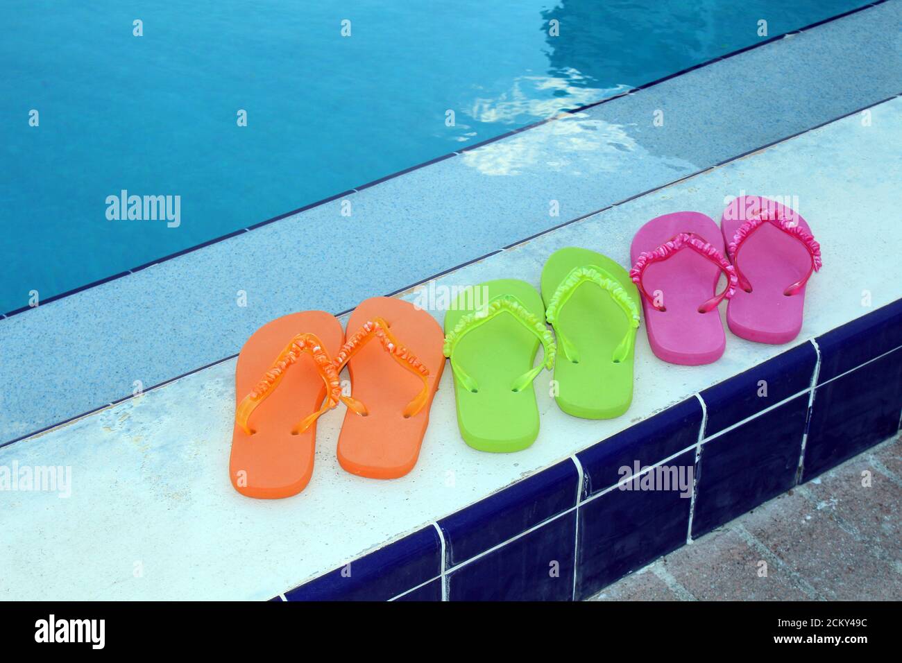 Colorful flip flops by the edge of a swimming pool Stock Photo - Alamy