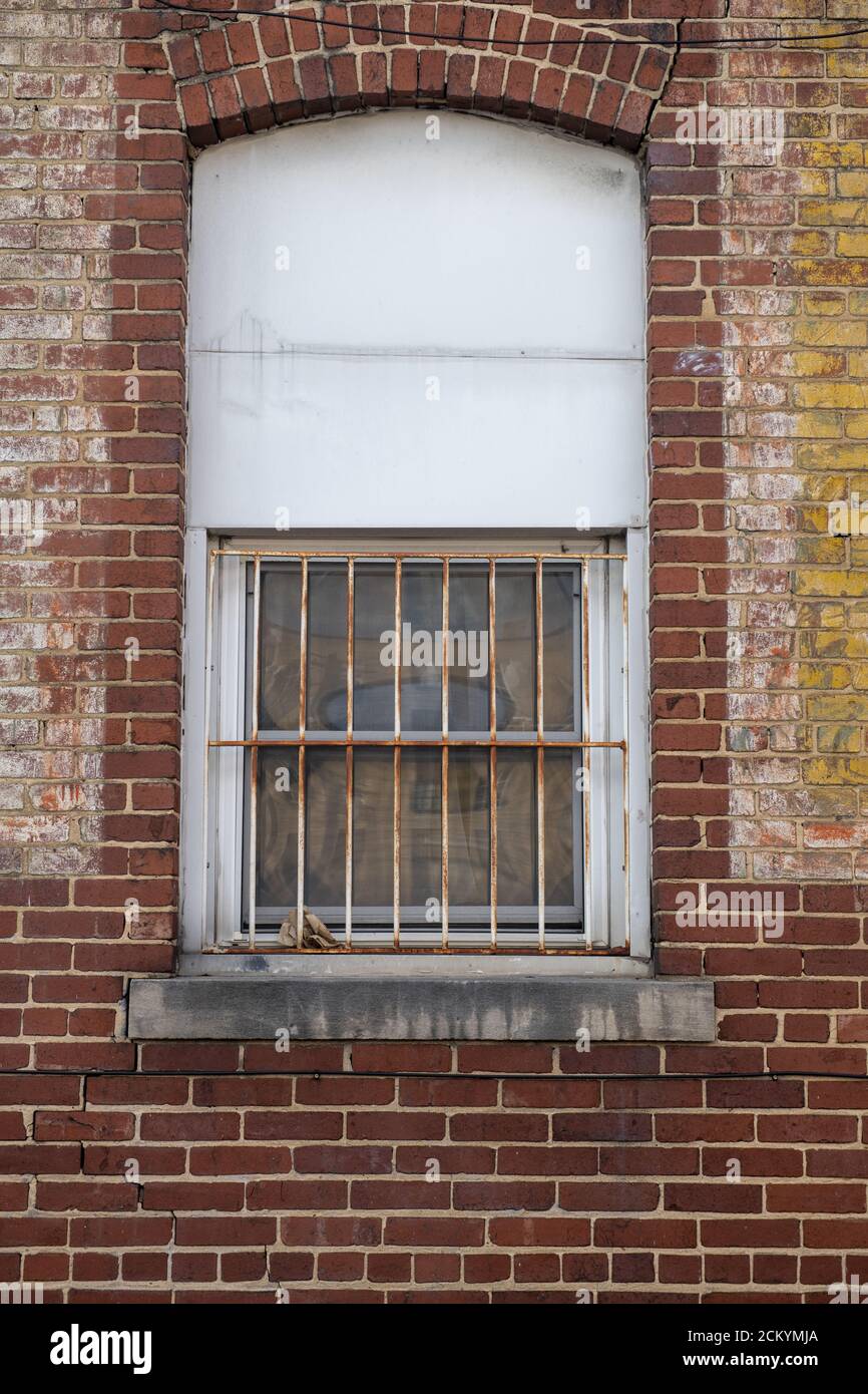 Vertical shot of rusty bars on window of a brick wall Stock Photo - Alamy