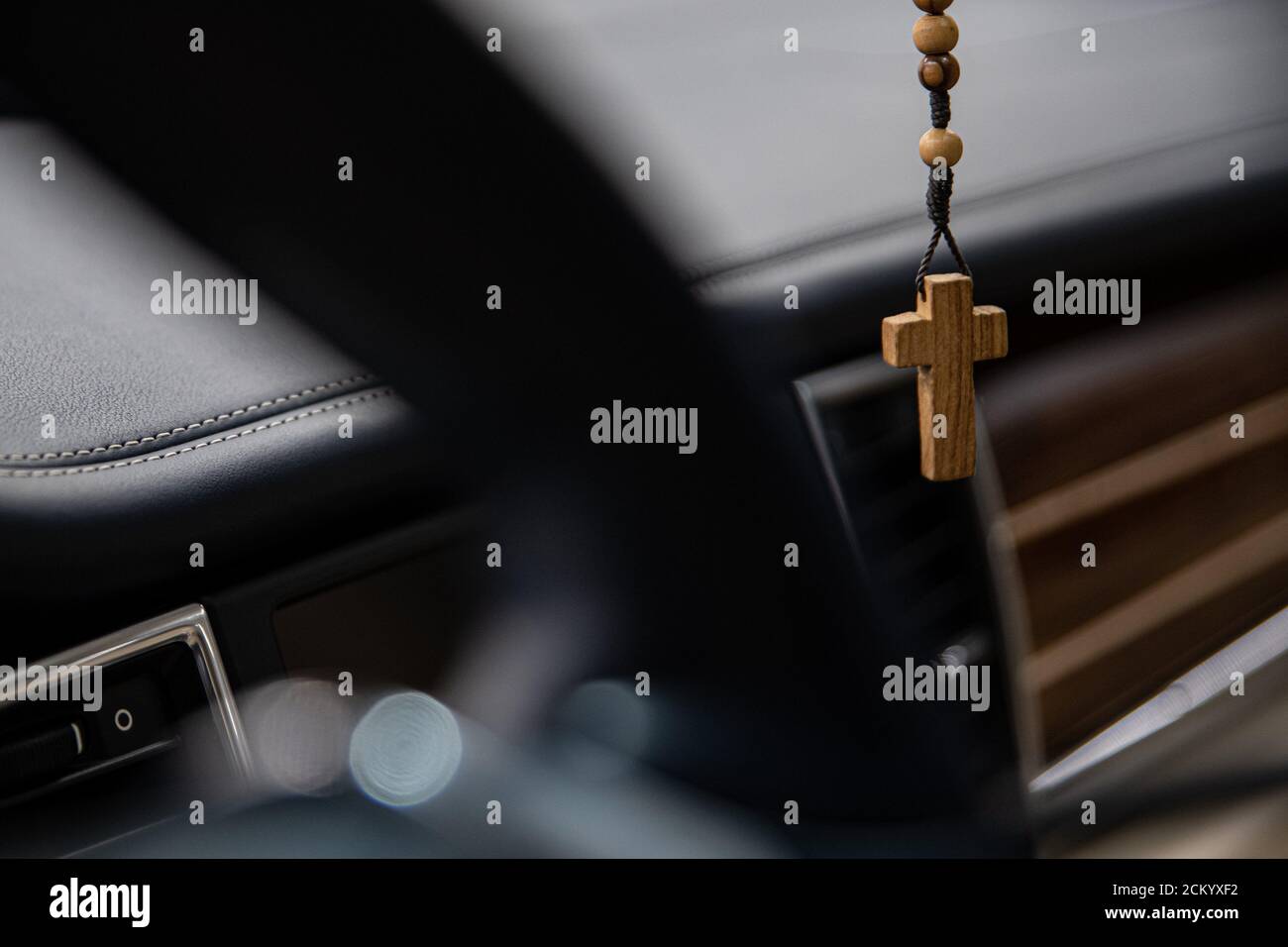 Wooden Christian cross hanging from rear mirror in car Stock Photo - Alamy