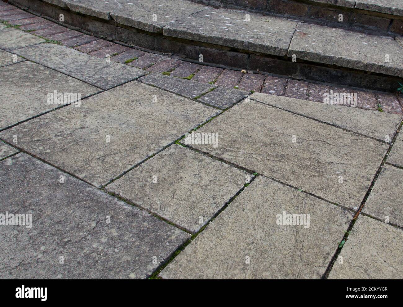 Old weather stained paving patio background with steps and bricks Stock ...