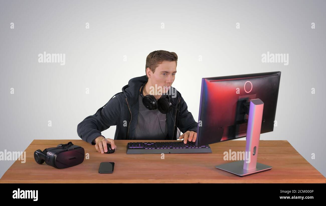 Gamer guy with headphones playing video games on computer and sh Stock ...