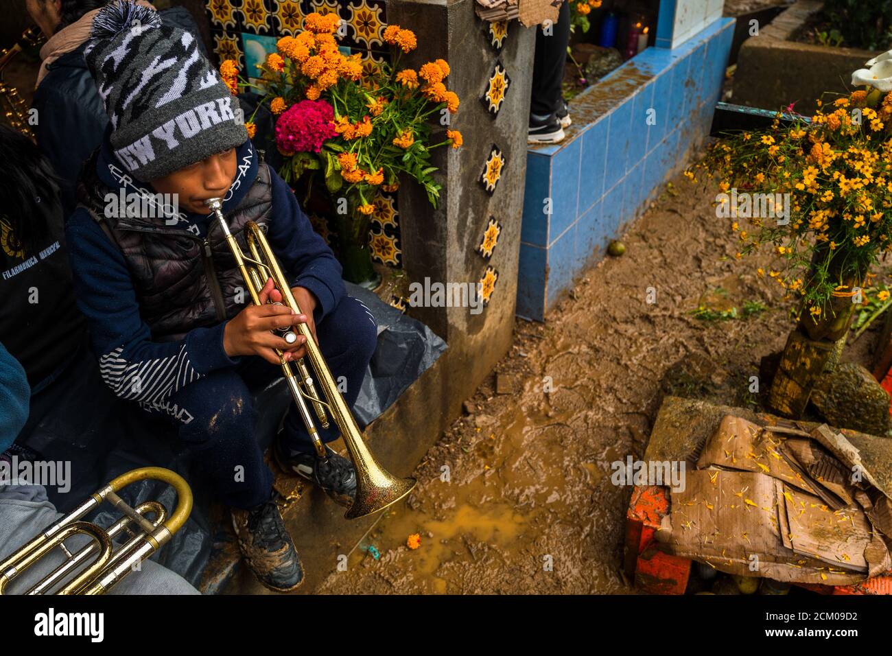 A Mexican boy plays a trumpet at a cemetery during the Day of the Dead ...