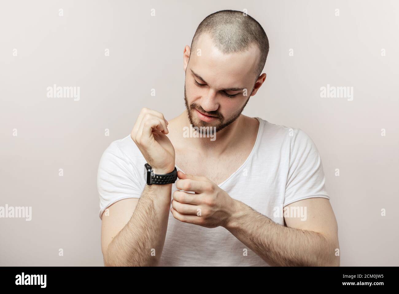 smiling, positive guy is putting on the watch on the arm. close up ...