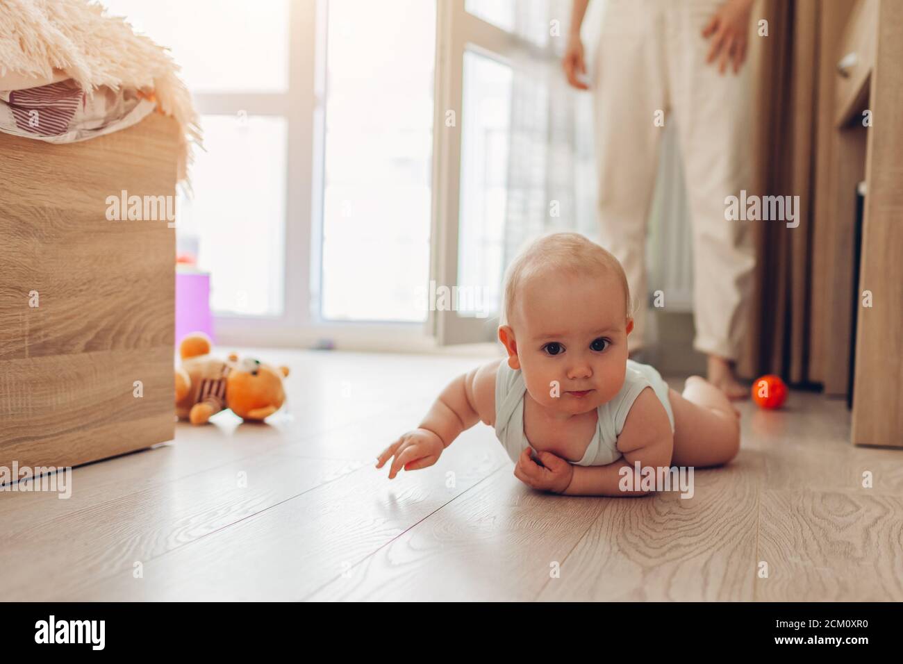 Infant crawling on floor in bedroom. Little baby having fun at home ...