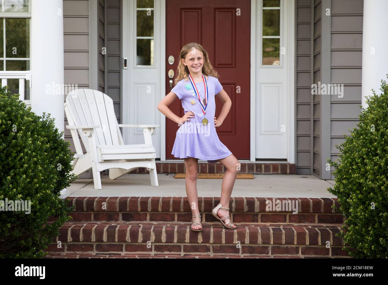 Smiling Sassy Blonde Girl Wearing Medal Poses on Brick Front Steps ...