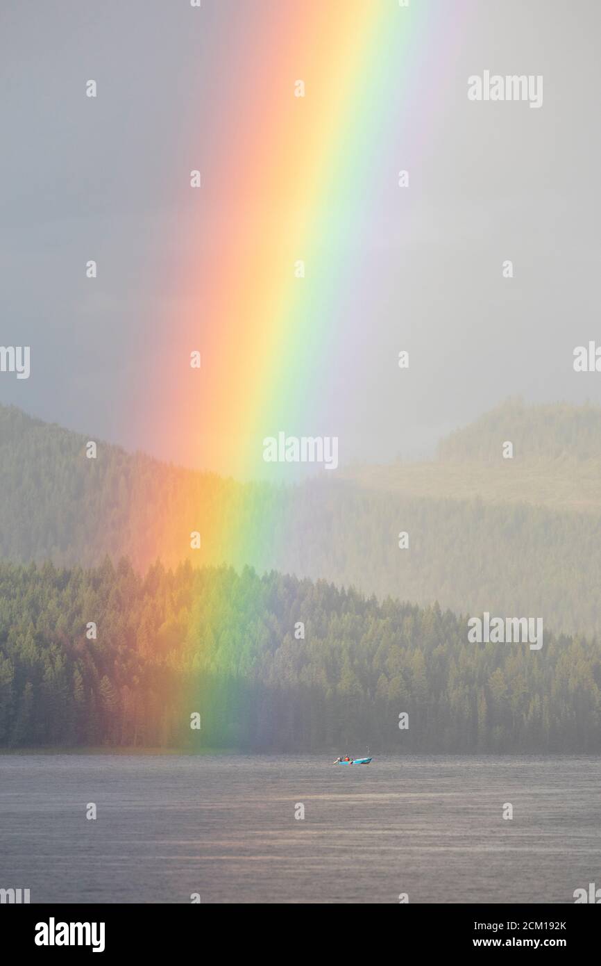 Bright rainbow over lake in nature Stock Photo - Alamy