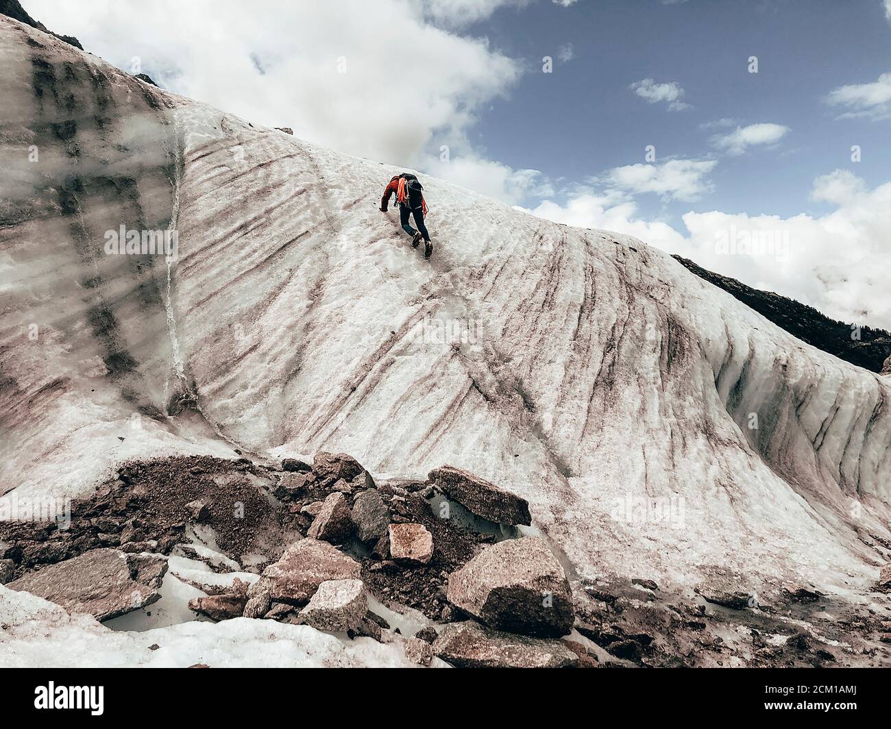 Mountaineer climbing up ice face next to running melt-water river Stock ...