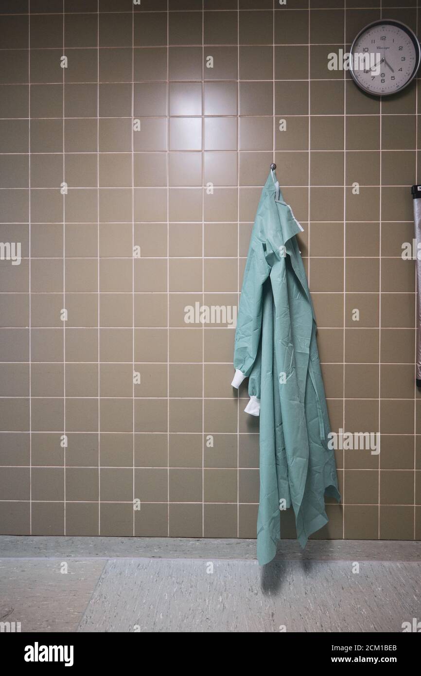 a green surgical gown is hanging on a wall in an operating room Stock ...