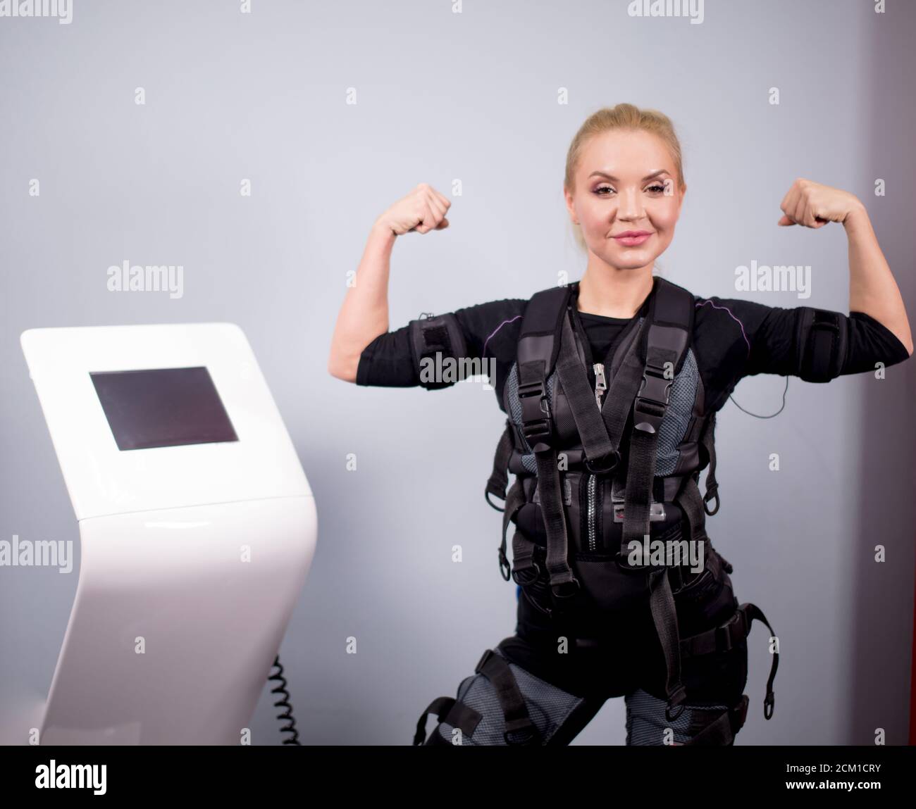 stong positive blond fit girl wearing EMS costume is showing her ...