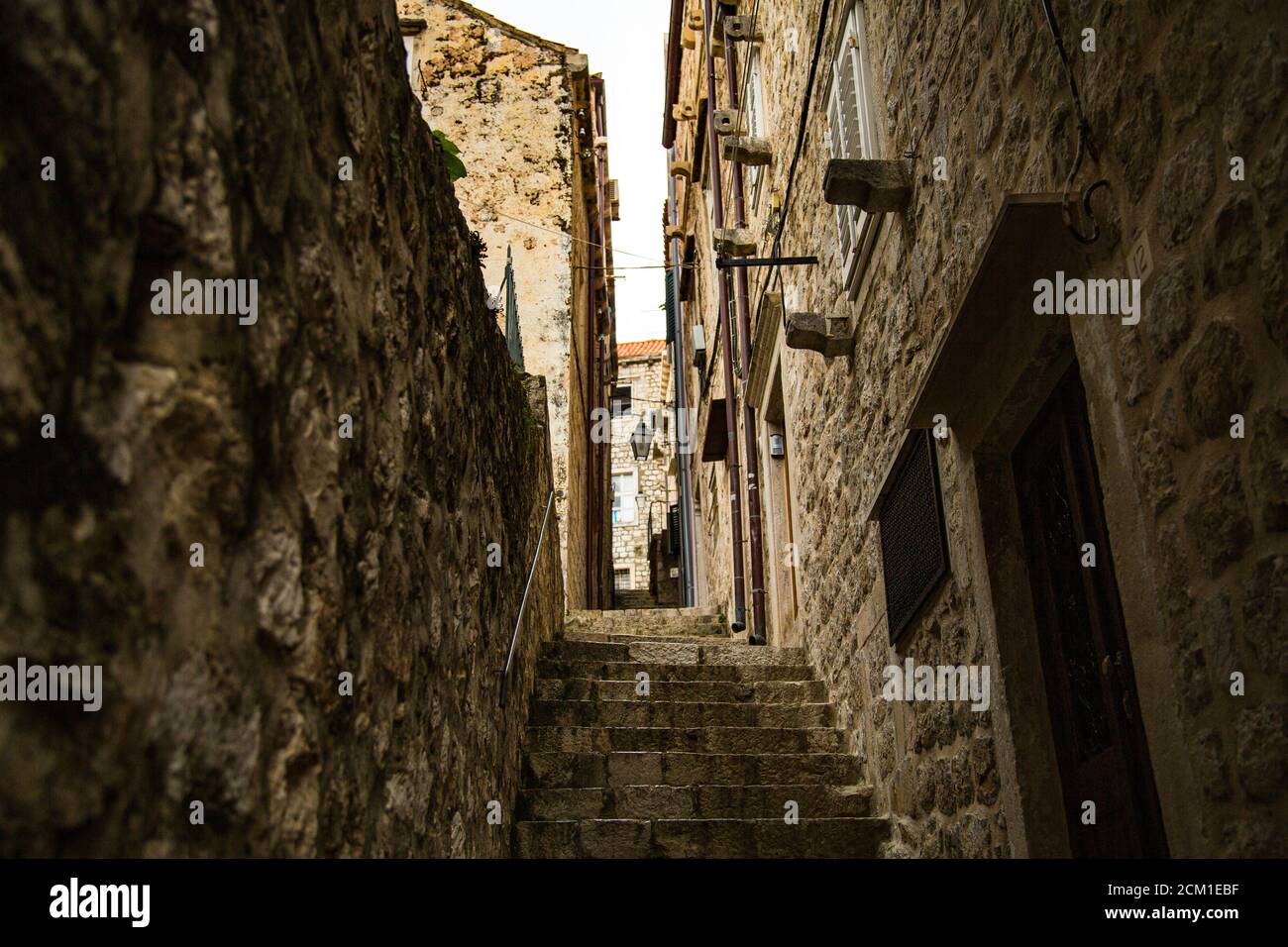 Alley of stairs with facades and stone wall Stock Photo - Alamy