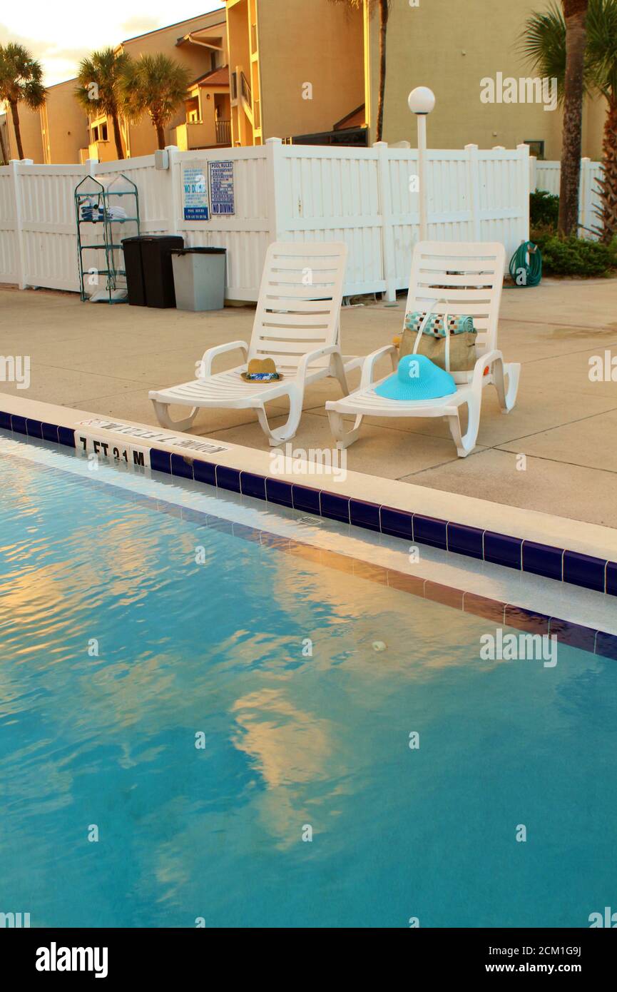 Lounge chairs by a swimming pool Stock Photo - Alamy