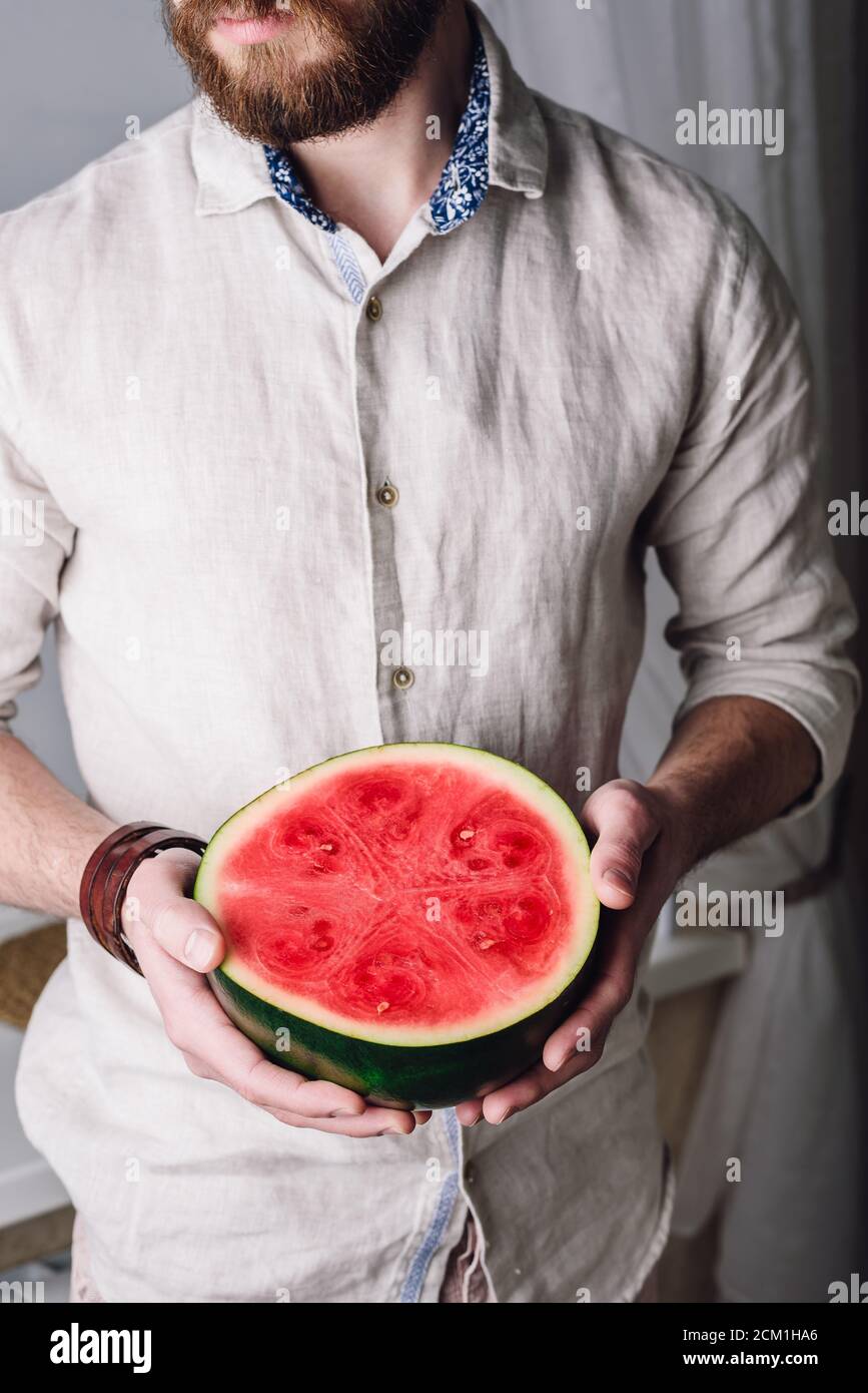 Bearded man with half of ripe watermelon Stock Photo - Alamy