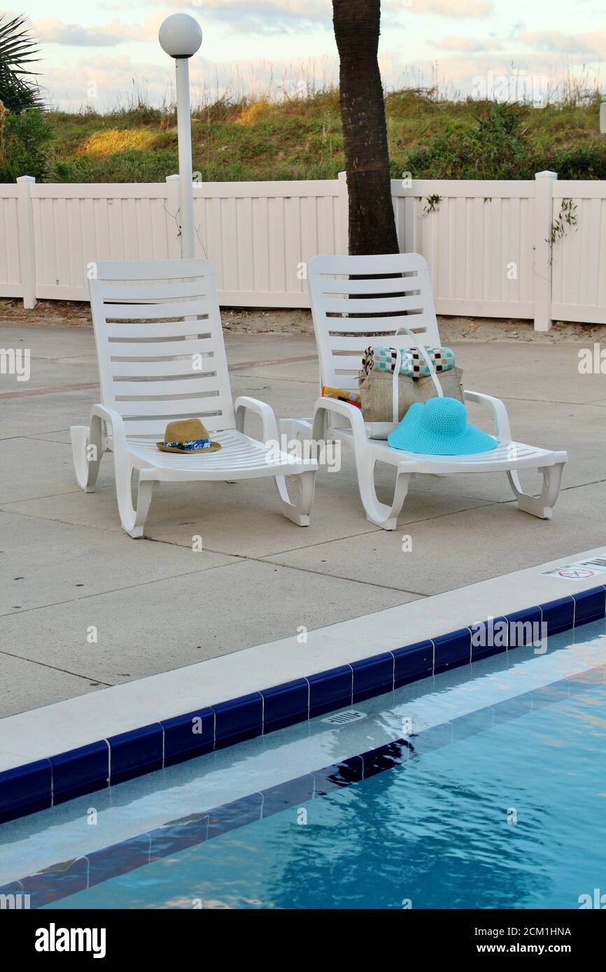 Lounge chairs by a swimming pool Stock Photo - Alamy
