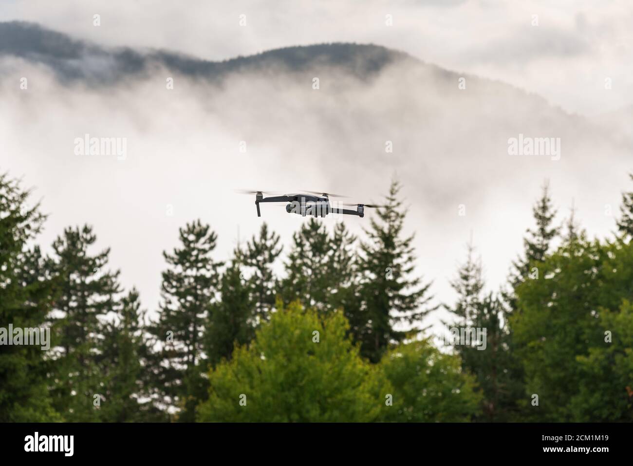 Drone with camera flying over mountain fields. Aerial photography and ...