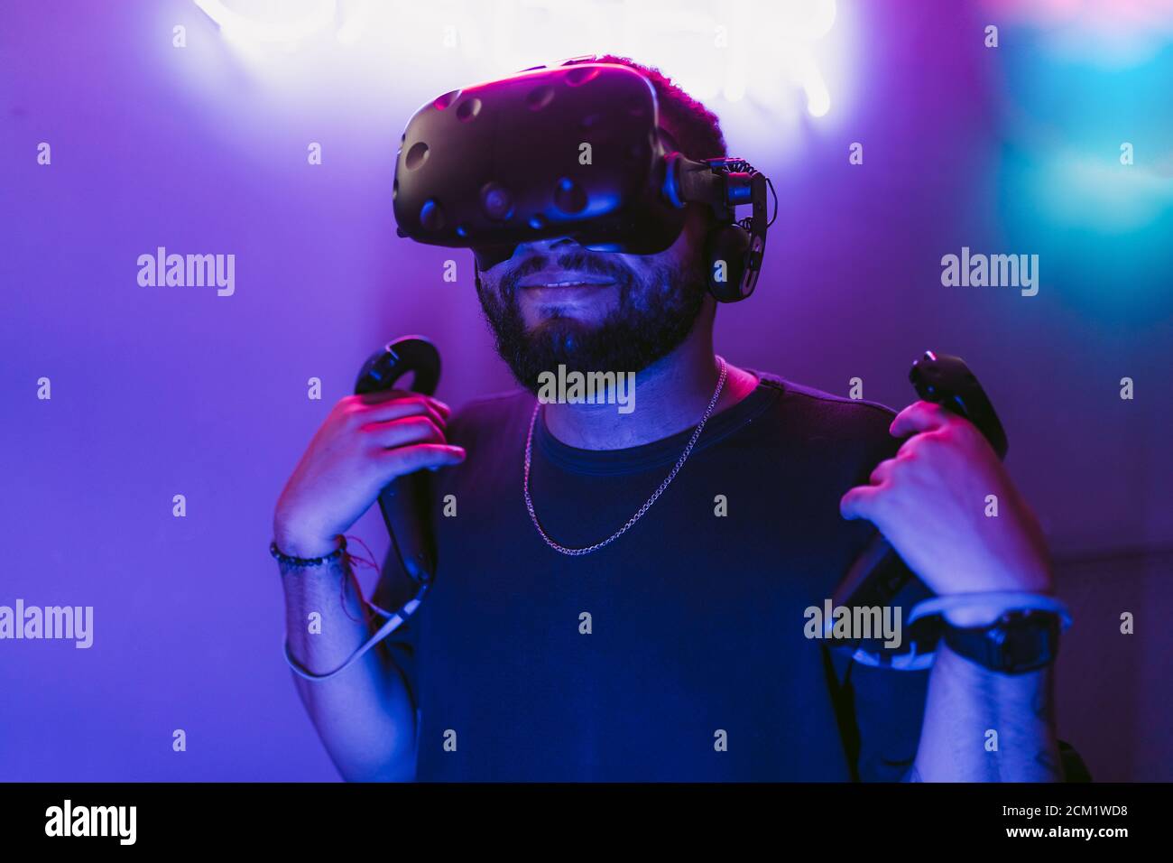 The guy is playing VR games. Neon blue light Stock Photo - Alamy