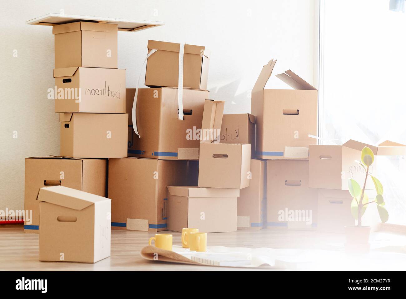Moving in. Stack of cardboard boxes in room of new home Stock Photo - Alamy