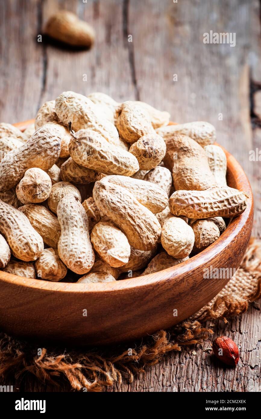 Peanuts in shell in a wooden bowl, selective focus Stock Photo - Alamy