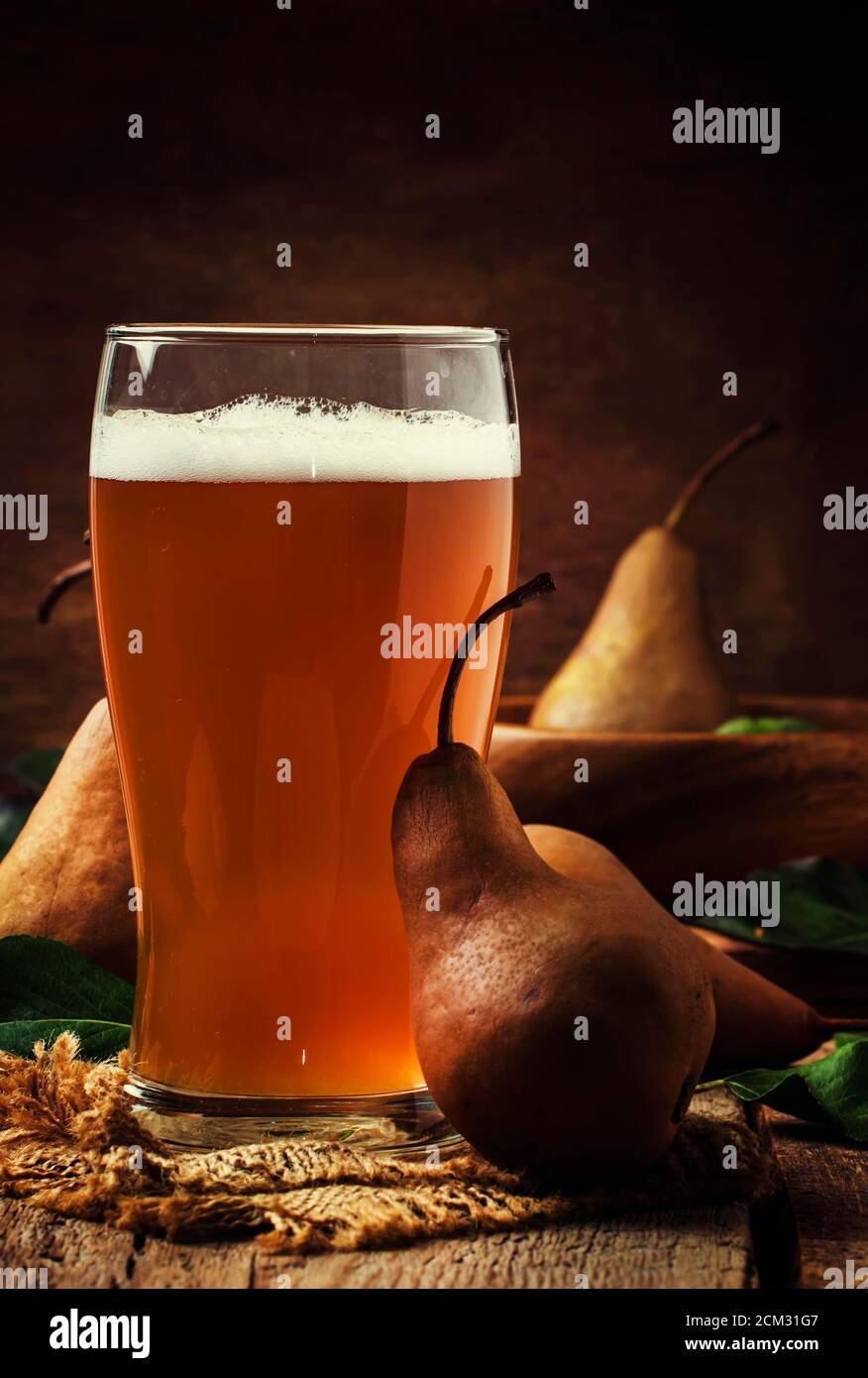 Pear cider in a large beer glass, old wooden background, selective ...