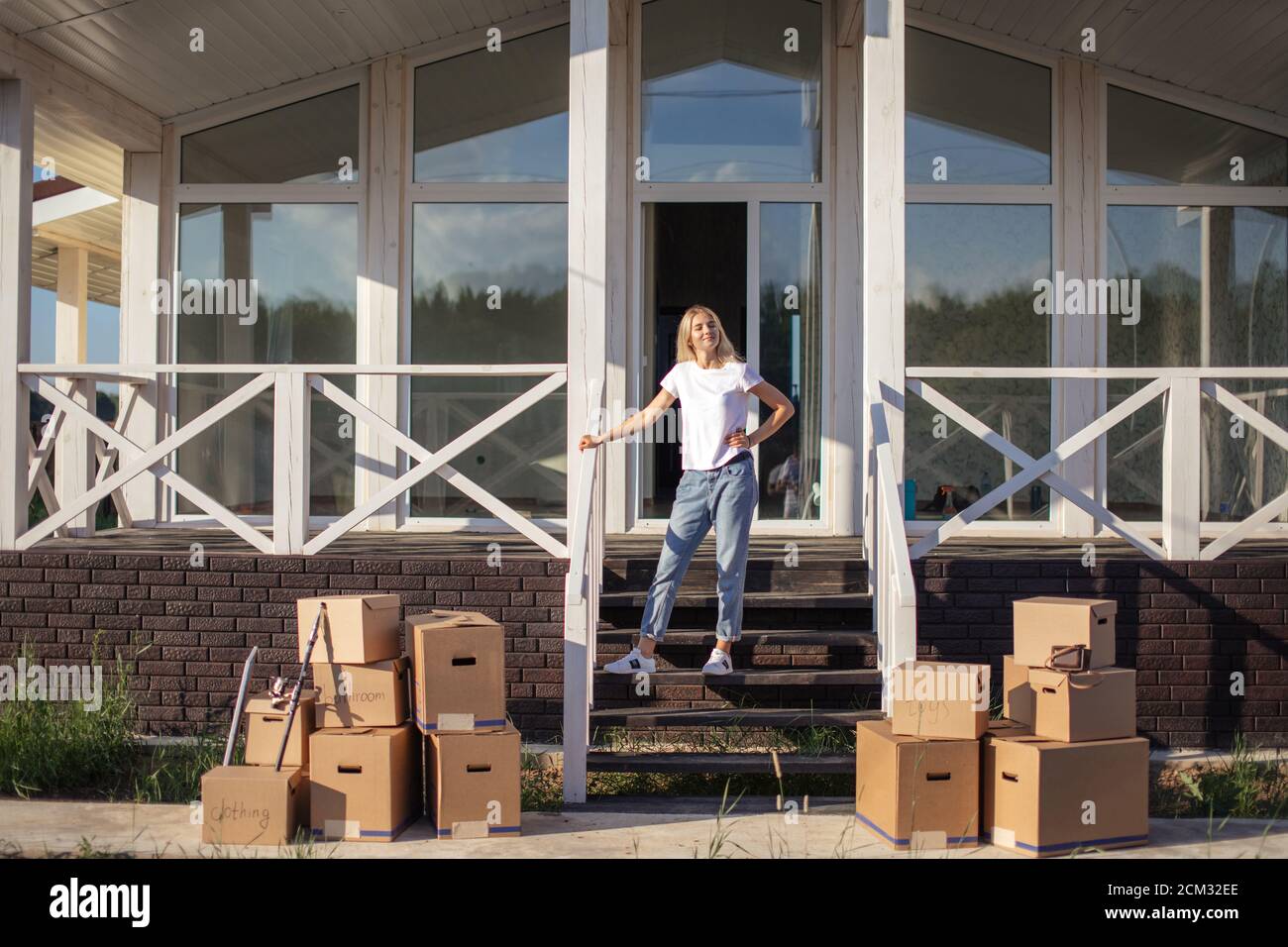 Blonde woman moved in new light house. Girl waiting movers to move ...