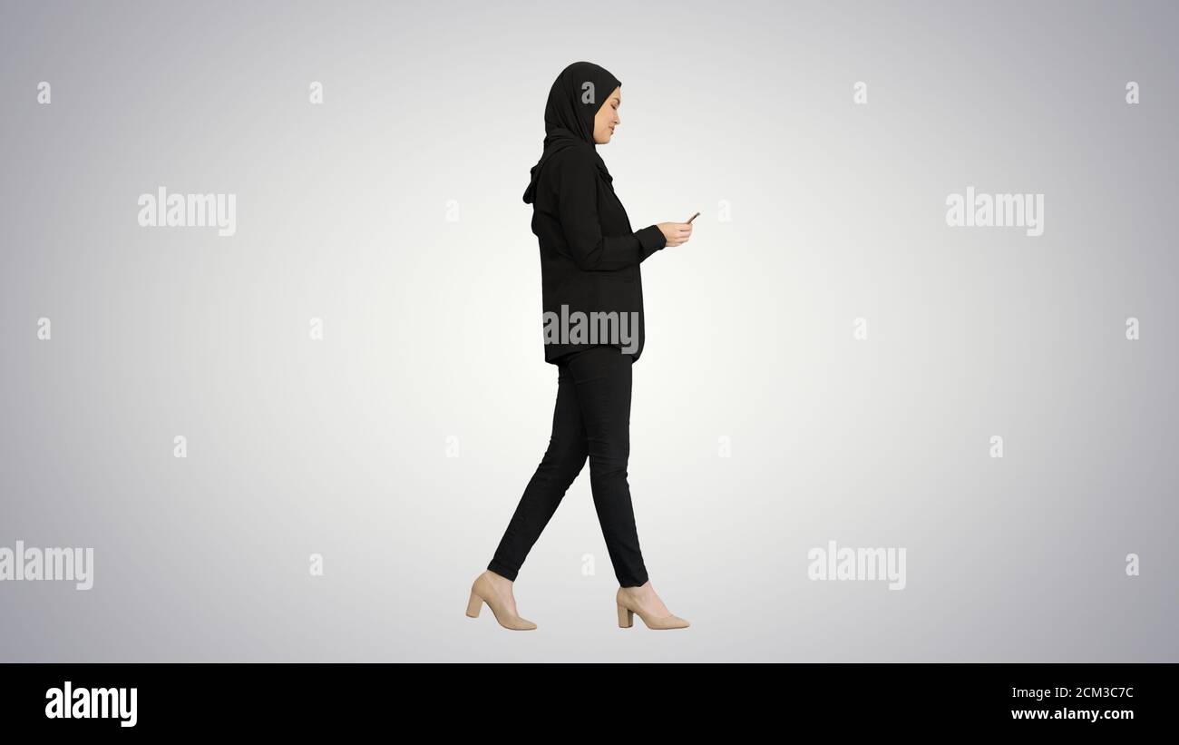 Pretty woman in hijab walking and counting money on gradient bac Stock ...