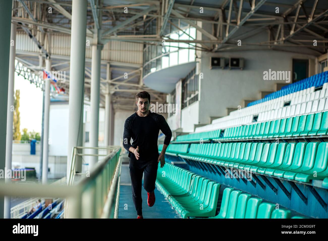 Fit athlete runner run on tribune along of chairs Stock Photo - Alamy