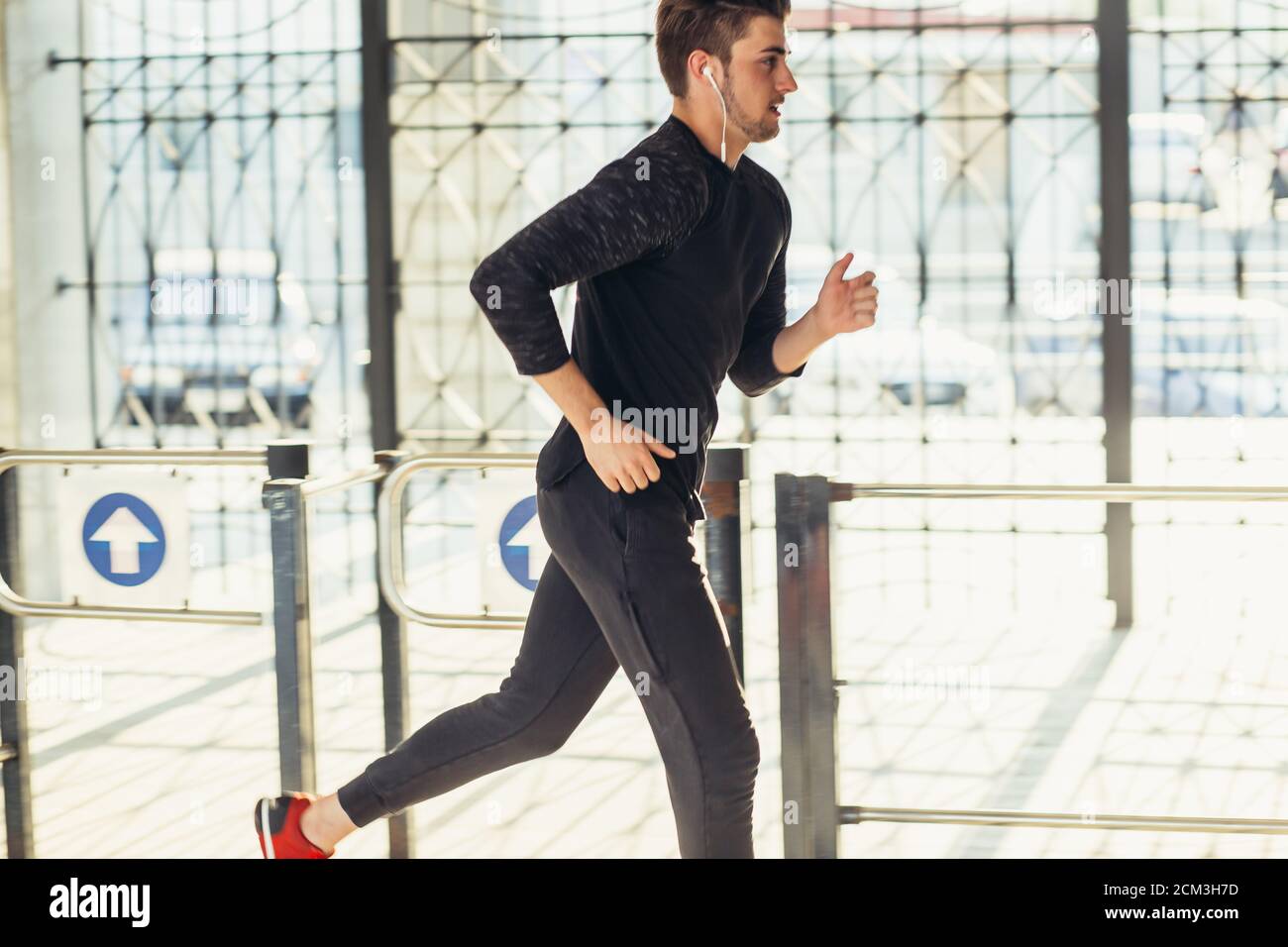 handsome young man running in sunset near fence Stock Photo - Alamy