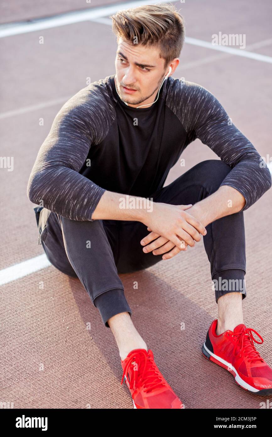 man sitting on race track and rest after jogging Stock Photo - Alamy