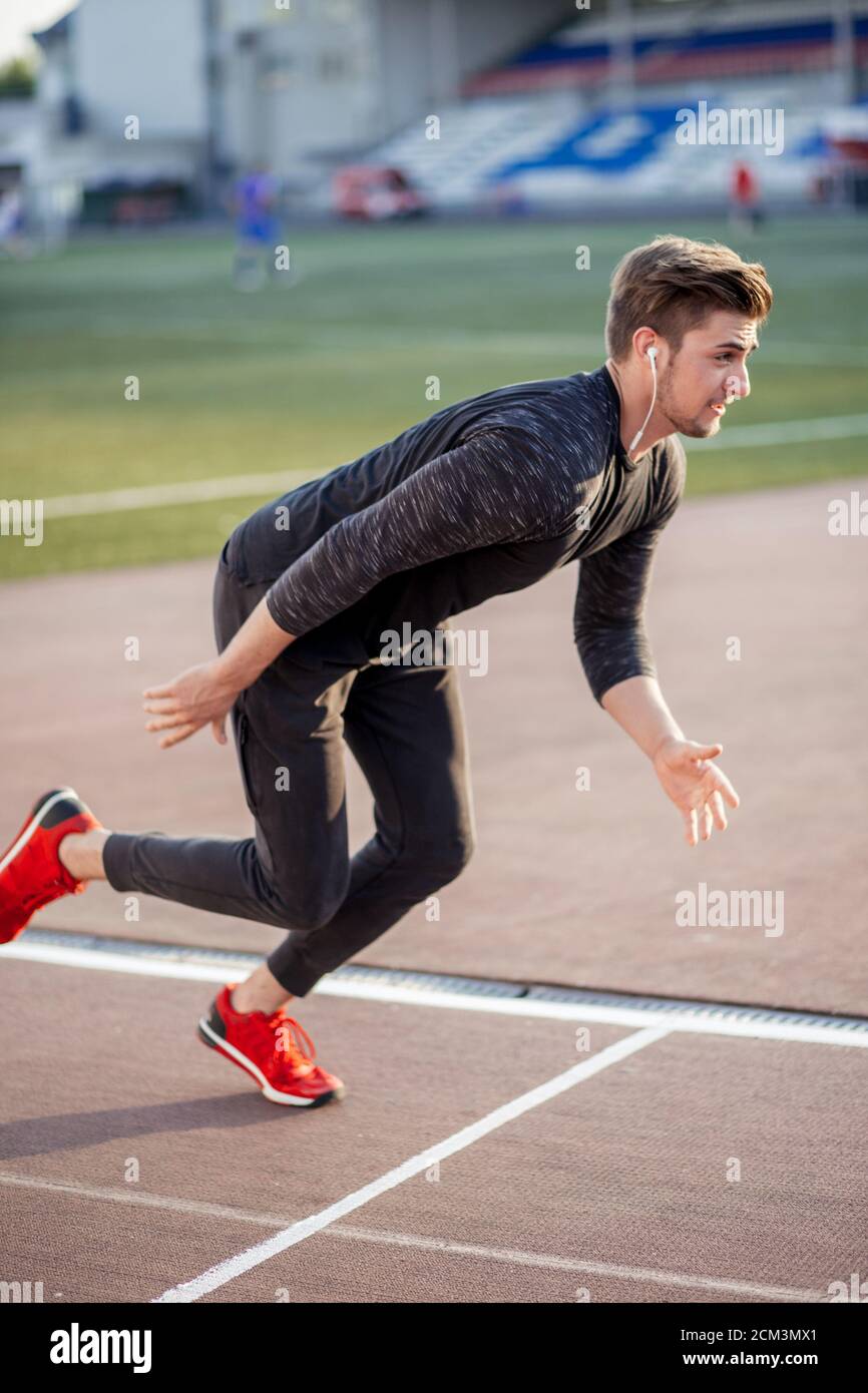 young male athlete launching start line in race track Stock Photo - Alamy