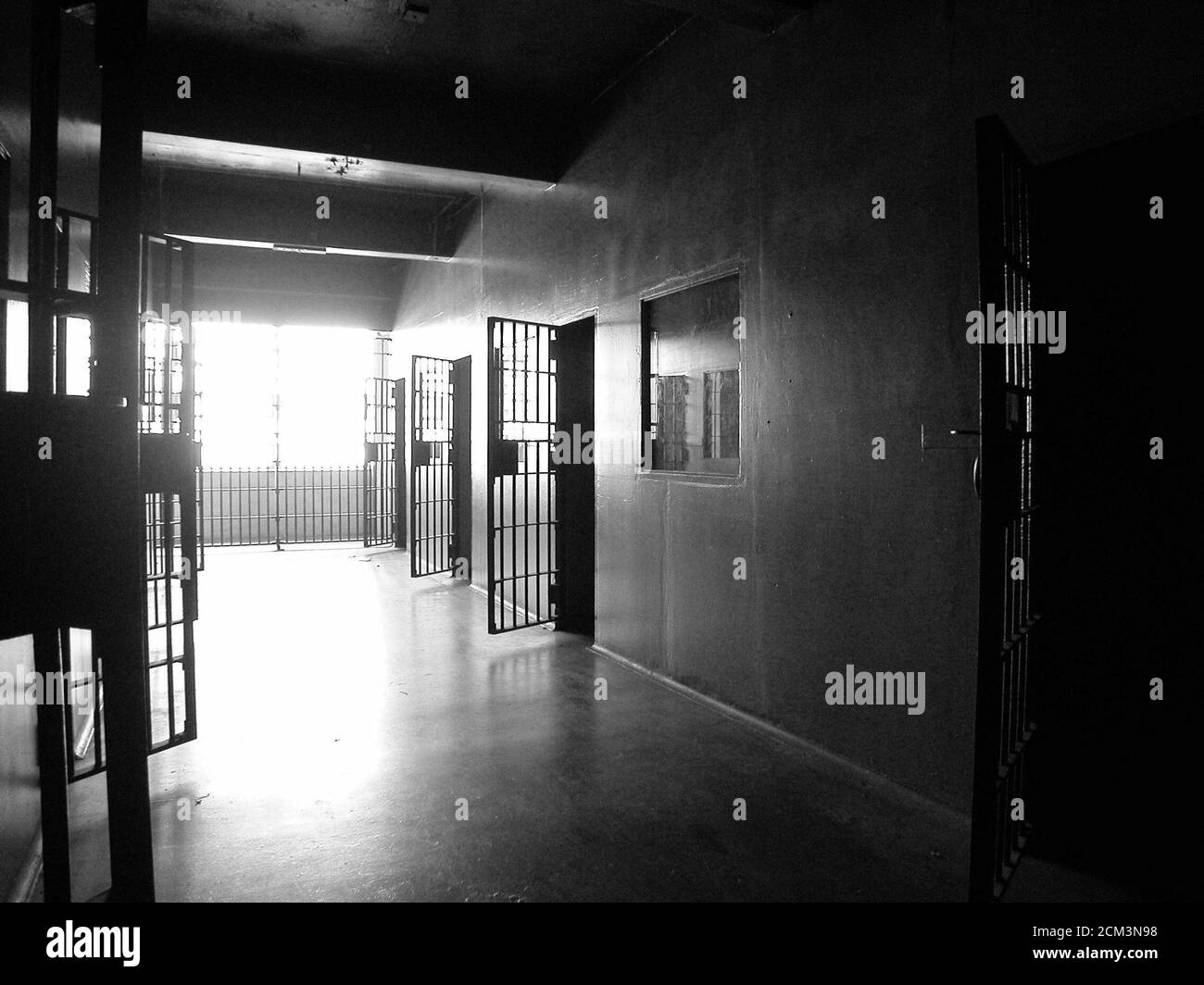 Black and white view of rundown jail cell block in an unused government ...