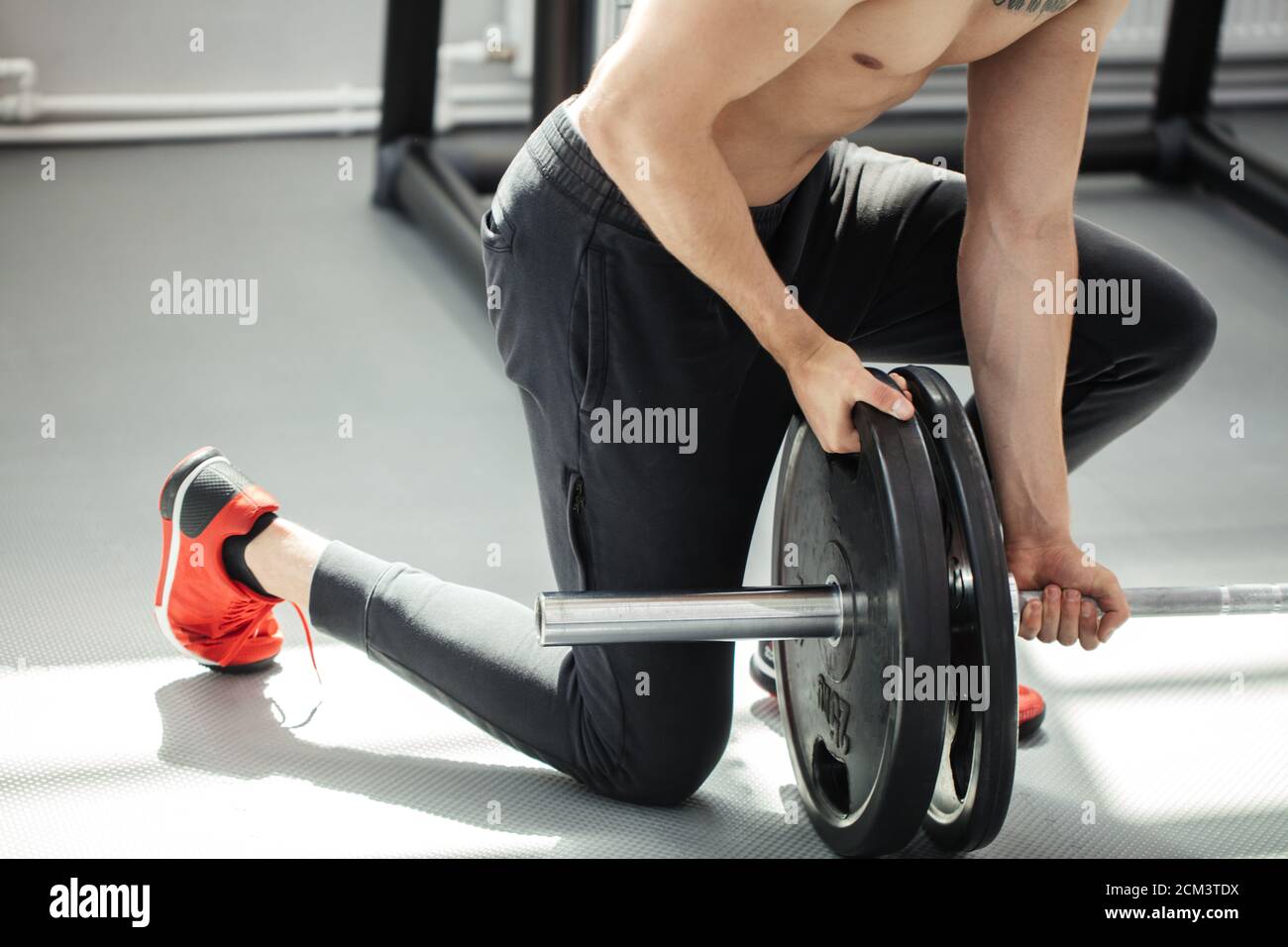 Close-up view of muscular man putting weight on dumbbell in gym Stock ...