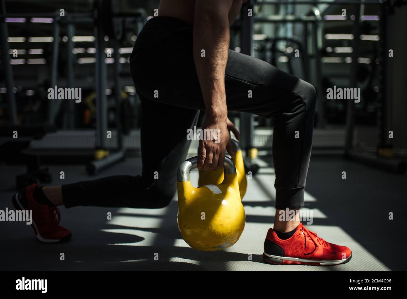 Handsome bodybuilder pumping up muscular body, doing exercises in gym ...